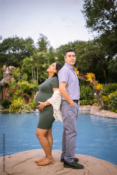 Husband And Pregnant Wife Touching Each Others Backs Near Swimming