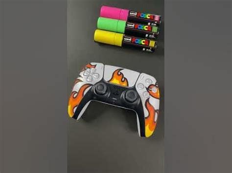 A Video Game Controller With Markers And Pens On The Table Next To It Is An Image Of A Fire Theme