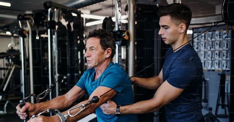 체육관에서 근력 운동을 하는 젊은 남성 트레이너와 함께 있는 노인 사진 Unsplash의 슬로바키아 이미지