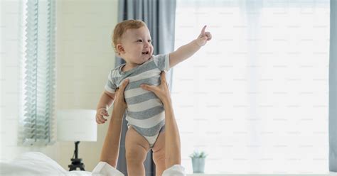 백인 사랑하는 엄마는 침실에서 침대에서 귀여운 남자 아이와 놀고 있습니다 행복한 가족 매력적인 아름다운 돌보는 젊은 어머니가 집에서 이른 아침에 유아 유아 아들과 들어