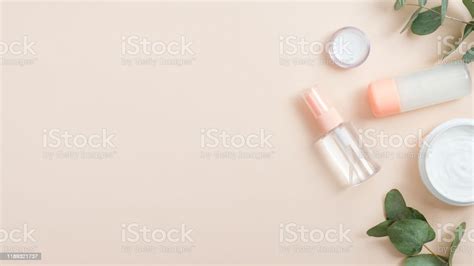 파스텔 베이지 색 배경에 손 관리 및 녹색 허브 잎에 대한 에센셜 오일 화장품 병 투명 용기 자연 미용 제품 컨셉 최소한의 플랫 레이 스타일 구성 공중 뷰에 대한 스톡 사진