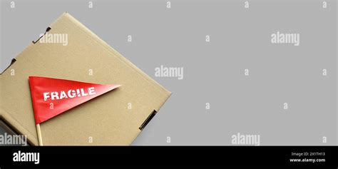One Cardboard Packaging Box On Monochrome Background Tiny Red Paper
