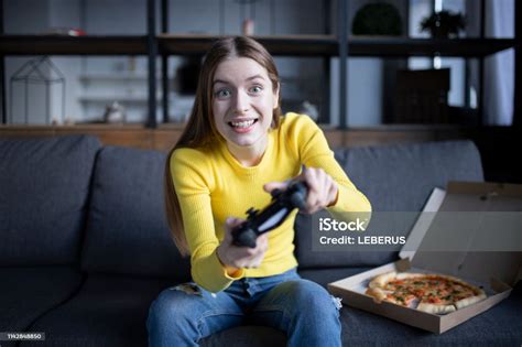 귀여운 소녀는 콘솔에서 게임을 재생 하 고 피자를 먹는다 비디오 게임에 대한 스톡 사진 및 기타 이미지 비디오 게임 속도 Brand Name Video Game