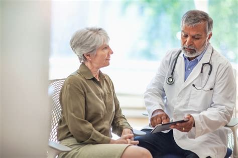 아시아 인도 태평양 섬 주민 노인 남성 의사가 건강 클리닉의 노인 여성에게 디지털 태블릿을 사용하여 이야기하는 의료 전문가 의사에 대한 스톡 사진 및 기타 이미지 Istock