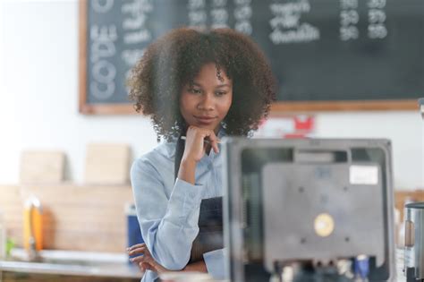 성공한 젊은 바리스타 여성이 카페의 바 카운터에 서 있다 작은 스타트업 소유자 개념입니다 앞치마를 두른 행복한 커피숍 여자 웨이트리스가 카페에서 자신 있게 웃고 있다