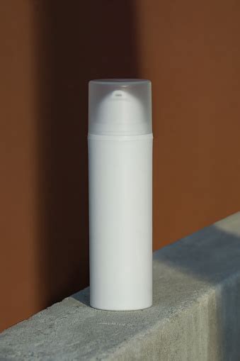 얼굴 바디 케어 화장품 병 콘크리트 연단에 디스펜서와 함께 갈색 모형에 흰색 상표가 없는 Flacon 영양 공급 또는 보습 폼