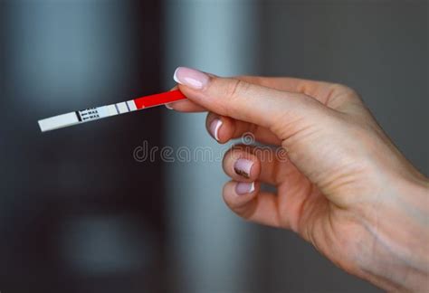 Woman Hand Holding Positive Pregnancy Test With Two Lines On It