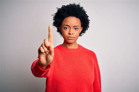 젊은 아름다운 아프리카 계 미국인 Afro 여자 곱슬 머리 를 입고 빨간 캐주얼 스웨터 가리키는 손가락과 화가 표정 아무