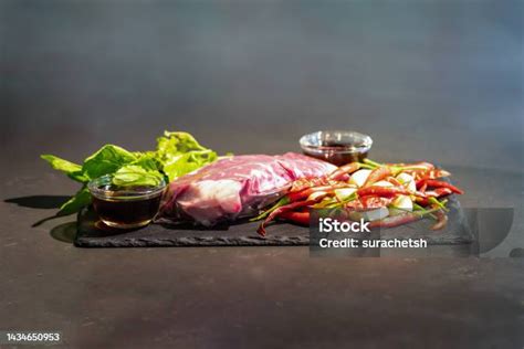 생 쇠고기와 허브 재료 바질 잎 마늘 칠리 소스는 태국 음식 메뉴 볶음 쇠고기 바질에서 다음 요리 과정을 위해 검은 돌 슬레이트