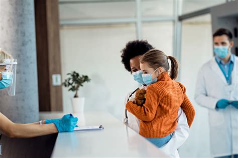 코로나바이러스 전염병 중 병원의 리셉션 데스크에서 흑인 여성 의사와 어린 소녀 접수원에 대한 스톡 사진 및 기타 이미지 접수원 병원 여자 의사 Istock