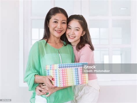 십 대 소녀 딸에서 선물 상자를 들고 어머니 Daugther 창 배경 그녀의 엄마를 껴 안고 사랑 하 고 엄마 개념 상관 어머니에 대한 스톡 사진 및 기타 이미지 Istock