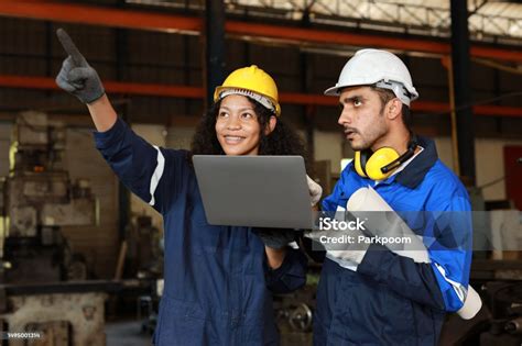워키토키 라디오와 컴퓨터를 사용하여 보호복을 입은 기술자 엔지니어 그룹이 산업 제조 공장에서 유지 보수 작업 선반 금속 기계를 가리키고 제어합니다 16 17 살에 대한 스톡