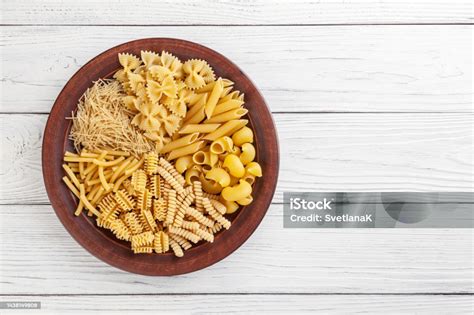 복사 스파아제가 있는 흰색 나무 배경에 세라믹 접시에 있는 이탈리아 파스타의 다양한 종류와 모양 0명에 대한 스톡 사진 및 기타 이미지 Istock