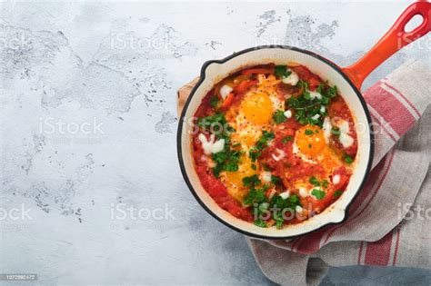 샤크슈카 밝은 회색 슬레이트 돌 또는 콘크리트 배경에 철 프라이팬에 야채와 계란 튀김 이스라엘의 전통 요리 늦은 아침 식사 개념 상단 보기 배너 0명에 대한 스톡 사진 및