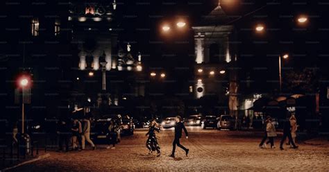 저녁 도시 거리에서 빈 길을 달리는 연인 도시의 불빛에 손을 잡고 즐거운 시간을 보내는 세련된 커플 현대 여자와 남자 낭만적 인 프랑스 분위기 순간 사진