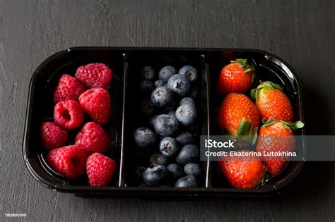 신선한 달콤한 딸기 딸기 블루 베리와 라즈베리트레이에 거짓말 검은 배경에 상자 수확 개념 검은 색 배경에 열매를 섞는다 텍스트에 대한 복사 공간이 있는 과일 건강한 식생활에