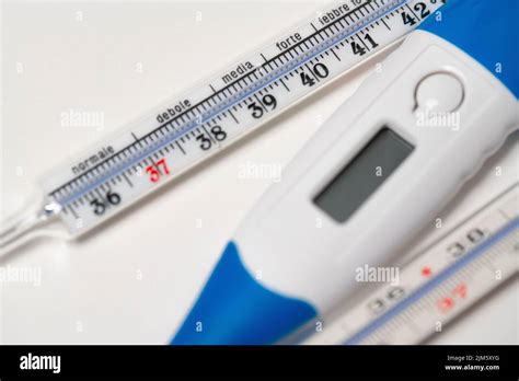 A Mercury Fever Thermometer On A Digital Clinical Thermometer For