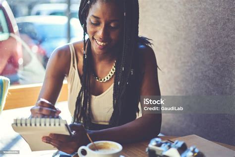 쾌활 한 아프리카 미국 유학생 과정 연구를 하 고 문서를 작성 하는 작업 작업을 완료 하는 재능 있는 기자 미소 카페 인테리어에 창조적인 솔루션을 만드는 만족 Stock