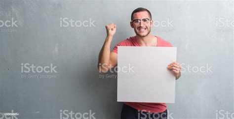 회색 Grunge에 젊은 백인 남자 벽 화가 빈 배너를 들고 고 미친과 제기 손으로 소리 분노와 좌절 외치고 분노 개념 감정에 대한 스톡 사진 및 기타 이미지 Istock