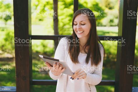 가벼운 캐주얼 옷을 입고 하는 매력적인 미소와 아름 다운 여자의 초상화 예쁜 소녀 태블릿 Pc 컴퓨터를 들고 봄 자연에 야외 거리에 도시 공원에서 뉴스를 읽고 라이프 스타일
