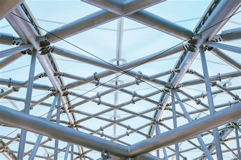 Unique Structural Design Showcasing Intricate Metal Framework Beneath A Clear Sky In A Modern