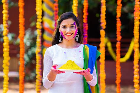 홀리 파우더 플레이트를 들고 카메라를 바라보며 얼굴에 홀리 컬러를 입은 행복한 웃는 소녀 다채로운 축제 축하 인도 문화와 전통 활력의 개념 홀리에 대한 스톡 사진 및 기타