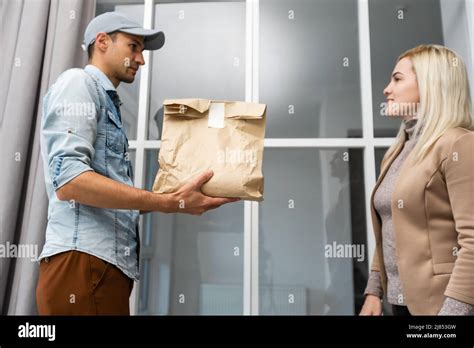 View Of A Delivery Man Handing Over A Parcel To Customer Stock Photo