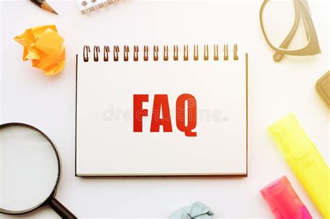 A Notebook Displaying The Word Faq Sits Next To A Magnifying Glass