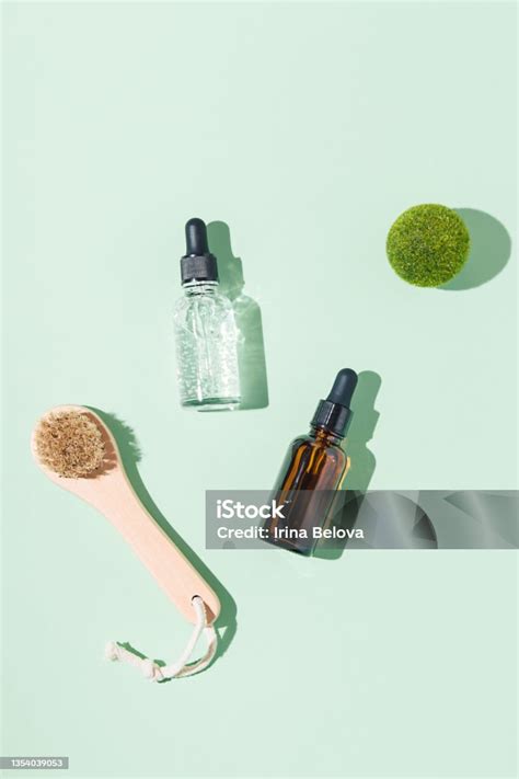 밝은 녹색 배경에 어둡고 투명한 유리로 만든 화장품에 대한 빈 병의 모형 바디 앤 페이스 트리트먼트 와 스파 천연 미용 제품