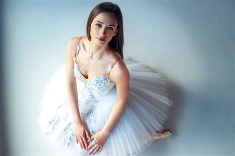 하얀 투투 의상을 입은 젊은 긴 머리 발레리나 발레 스튜디오에서 바닥에 앉아 있는 자세로 자연스러운 주변 일광 분위기 20 24세에 대한 스톡 사진 및 기타 이미지 Istock