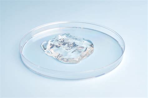 파란색 배경에 젤 또는 화장품 액체가있는 페트리 접시 거품이있는 젤이있는 투명한 용기 젤의 질감 의학 및 미용 개념 실험실용 의료용 유리 제품 0명에 대한 스톡 사진 및