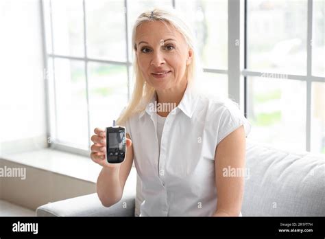 Mature Diabetic Woman With Glucometer At Home Stock Photo Alamy
