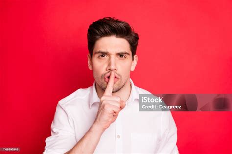 그의 클로즈업 초상화 그의 좋은 매력적인 초점을 맞춘 심각한 사람 보여주는 Shh 기호 유지 내 비밀 을 통해 고립 된 밝은 생생한 빛나는 빨간 배경 갈색 머리에 대한 스톡