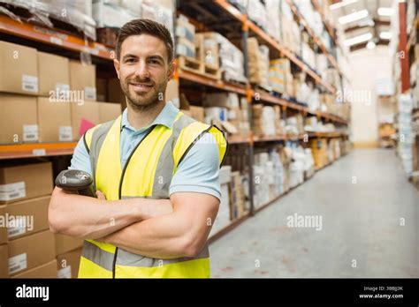 Male Warehouse Worker Scanning Barcodes In Warehouse Aisle With Scanner And Boxes Copy Space