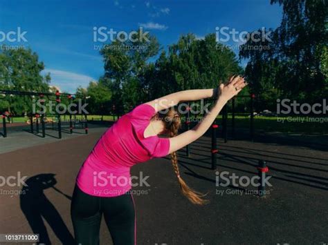분홍색 운동복 여름 아침에 거리 운동 장소에서 연습을 하 고 있는 소녀 코어 쪽 워밍업으로 굽어입니다 건강 한 라이프 스타일 스포츠 개념입니다 땋은 머리에 대한 스톡 사진