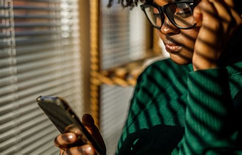 Close Up Shot Of Young Woman Replaying To Text Messages By The Window With Sun Rays Coming