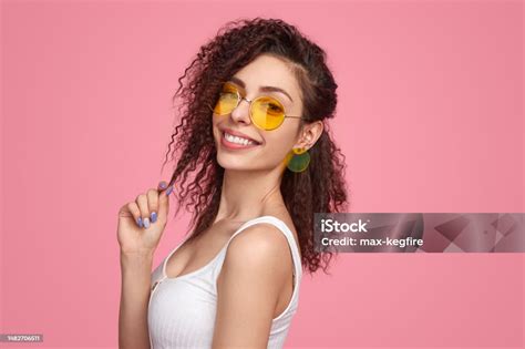 트렌디한 선글라스를 끼고 핑크색 스튜디오에서 웃고 있는 세련되고 자신감 넘치는 아가씨 20 24세에 대한 스톡 사진 및 기타 이미지 20 24세 갈색 머리 개성 개념