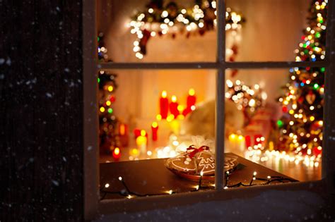 갈랜드 조명 양초 및 전나무 나무가있는 크리스마스 장식 된 객실 인테리어 겨울 서리가 내린 창 틀 테이블에서 산타를위한 Xmas 홀리데이 진저 브레드 쿠키 크리스마스에 대한