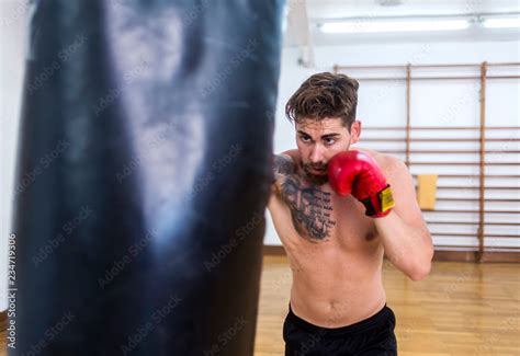 Babe Guy Trains In A Gym And Fists His Boxing Bag Fist Stock Photo Adobe Stock