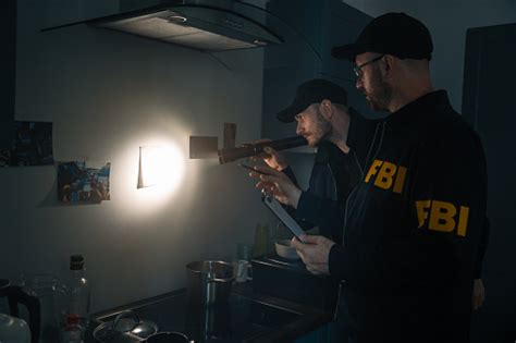 제복을 입은 두 명의 Fbi 요원이 범죄자 소굴의 어두운 방에서 범죄 현장을 검사합니다 범인에 대한 스톡 사진 및 기타 이미지 범인 메모장 25 29세 Istock