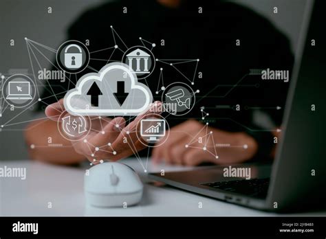 a man uses a laptop with a cloud computing diagram shown on hand cloud