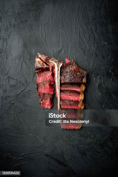 슬라이스 중간 희귀 구운 쇠고기 스테이크 T 뼈 또는 포터 하우스 컷 검은 돌 배경에 상단 보기 플랫 레이 텍스트복사 공간 검정색 배경에 대한 스톡 사진 및 기타 이미지