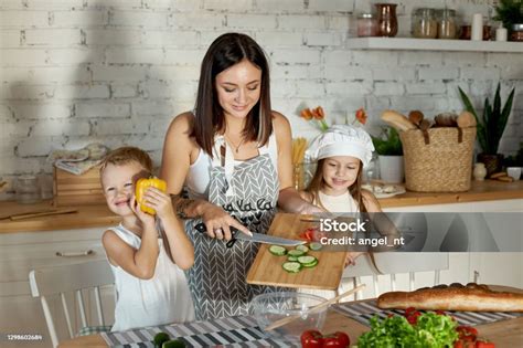 엄마는 아이들과 점심을 요리합니다 한 여성이 딸에게 아들로부터 요리를 하라고 가르칩니다 채식주의와 건강한 천연 식품 3 명에 대한 스톡 사진 및 기타 이미지 Istock