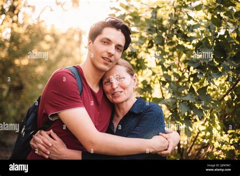 Portrait Of Happy Mother And Son Embracing Outdoors In Summer Stock