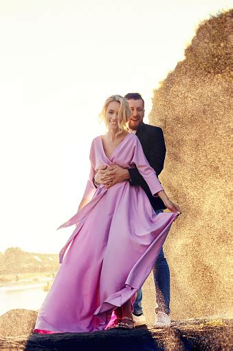 아름 다운 젊은 부부 포옹 하 고 멀리 고 서로 강에 낭만적인 데이트를 즐기고 남자와 여자에서 일몰 바다 근처의 태양에서 바위에 서 2명에 대한 스톡 사진 및 기타 이미지