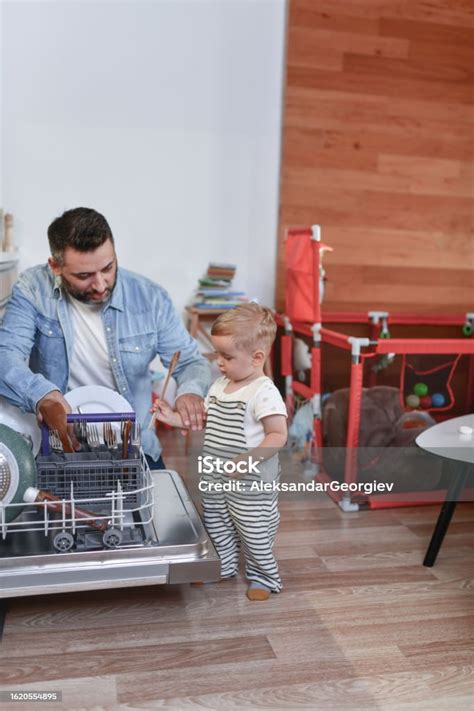 아버지가 집안일을 하는 동안 나무 숟가락을 식기세척기에 넣는 아기 2명에 대한 스톡 사진 및 기타 이미지 2명 가사 집안일 가정 생활 Istock