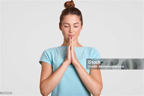 희망 여자 손바닥 함께 누르면 화이트 스튜디오 벽에 절연 된 캐주얼 옷을 입고 좋은 건강에 대 한 기도 여자가 보여줍니다 기도 제스처 희망 꿈을 실현 하나님 도와 귀여운에