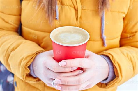 Фотография на тему Бумажный стаканчик с кофе в руках женщины в зимний