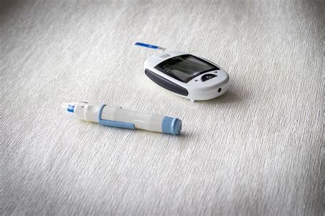 Close Up Shot Of The Glucometer Instrument On The White Surface