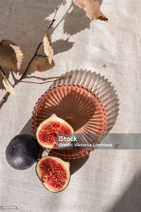 미적 최소한의 가을 음식 정물 중성 베이지색 린넨 식탁보 배경에 접시 마른 나뭇잎 가혹한 햇빛 그림자가 있는 무화과 열매를